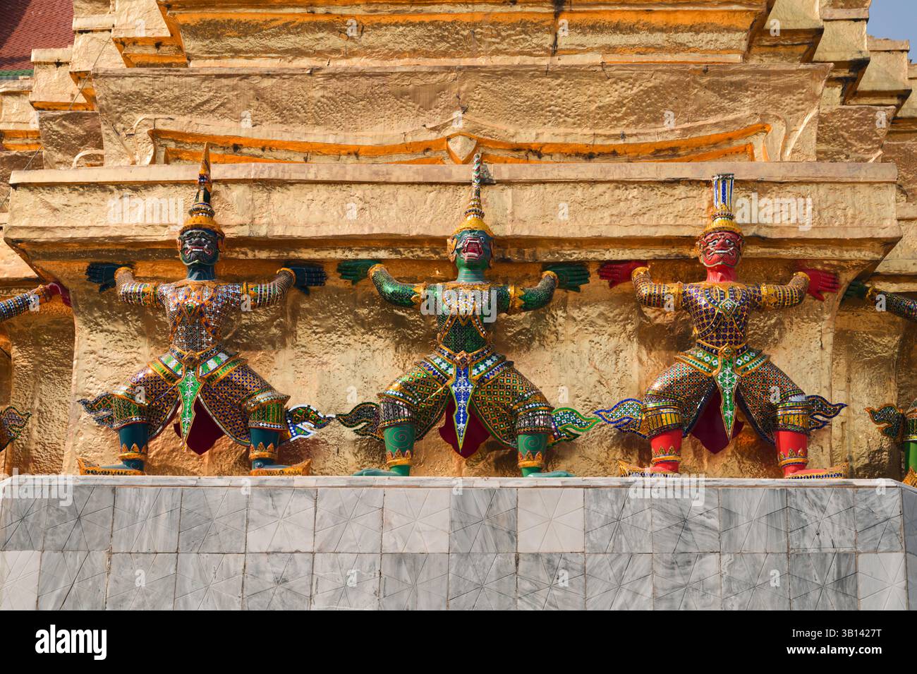 Colorful yaksha guardian statues hold up the golden chedi at the Grand ...
