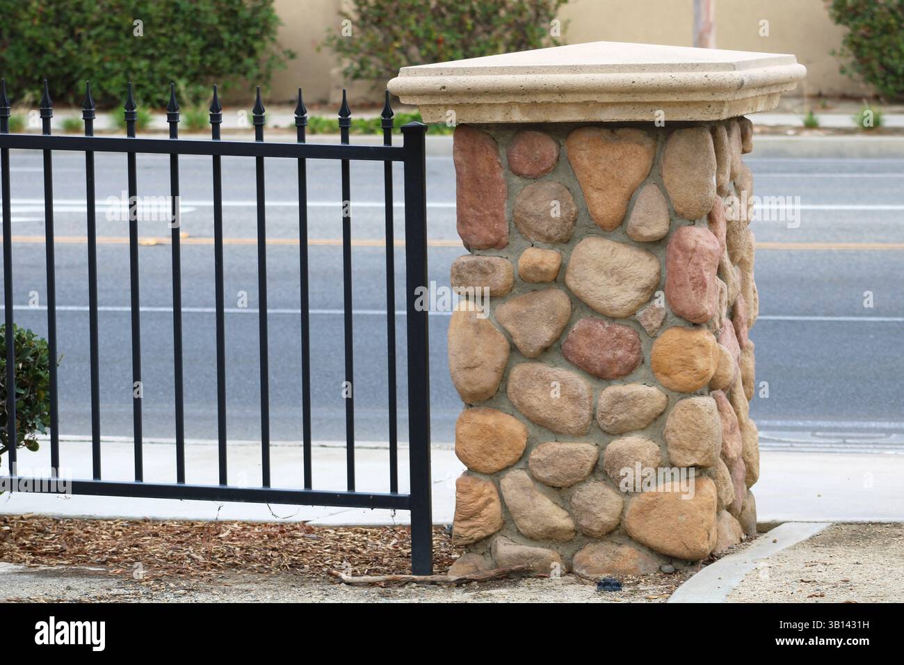 stone fixture at end of iron fence Stock Photo - Alamy