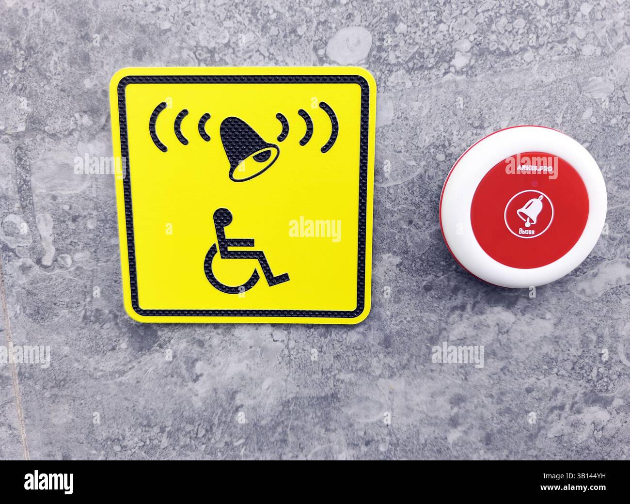 Accessible emergency alarm on gray tile wall with yellow wheelchair ...