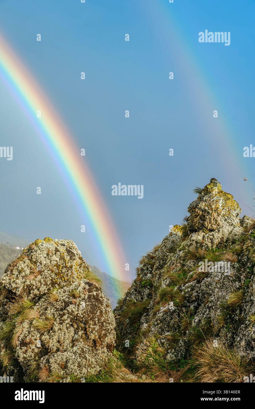 Double Rainbow Arches Over Mossy Rocks in the Azores Islands, Portugal. Natural phenomenon ...