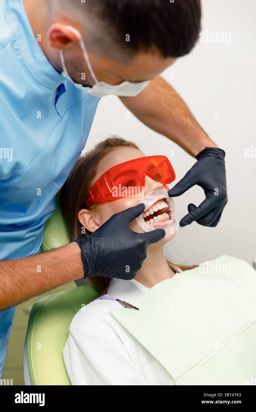 Dentist treating patient sitting hi-res stock photography and images ...