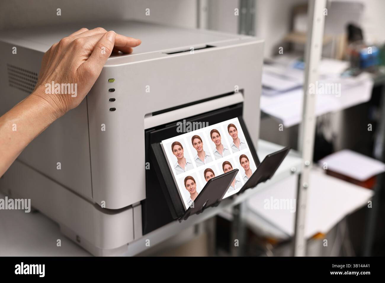 Worker using modern printer to print passport photos of woman indoors ...