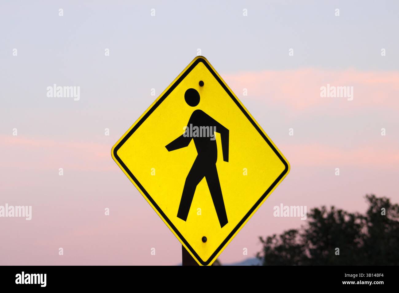 yellow crosswalk sign with sunset background Stock Photo - Alamy
