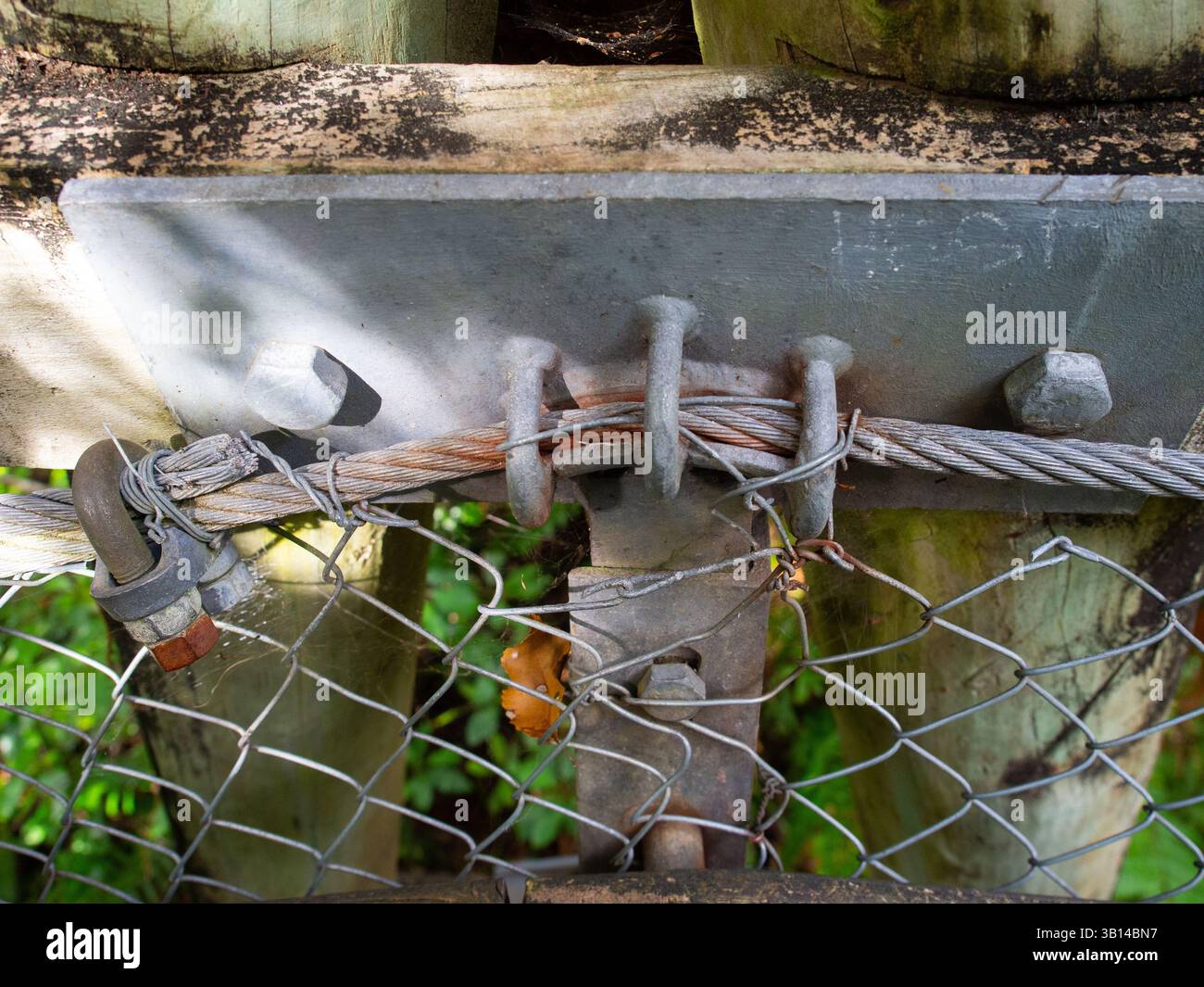 Close-up of heavy-duty metal cable and wire fence connection, secured ...