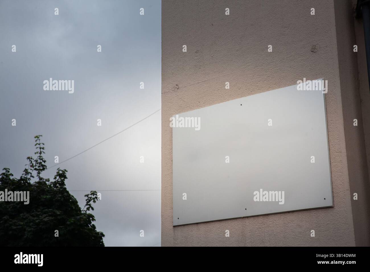 Blank rectangular grey signboard on an exterior wall of an office ...