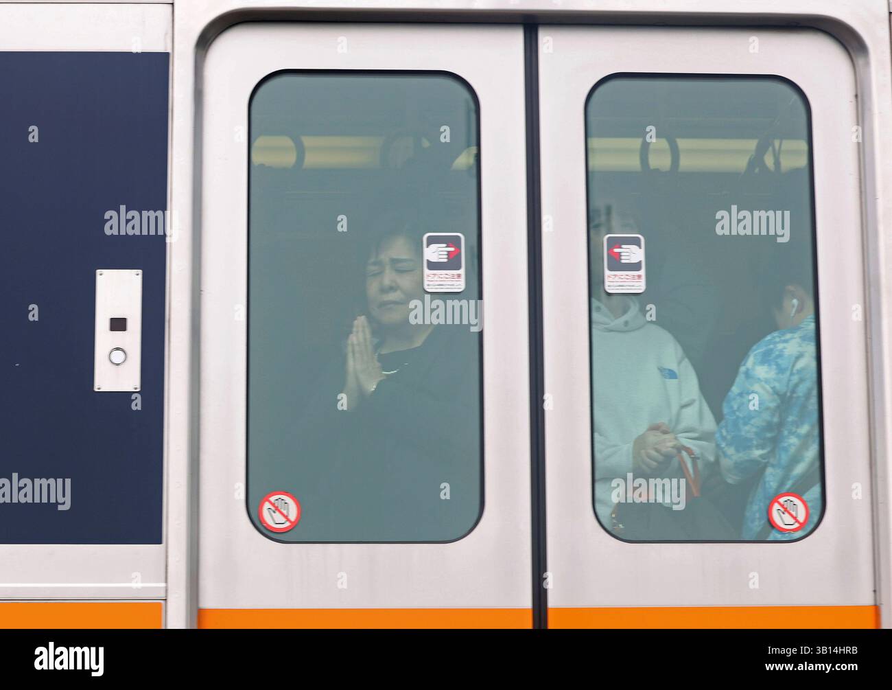 [CAPTION CORRECTION]A train passenger prays for the victims of a train derailment accident 20 ...