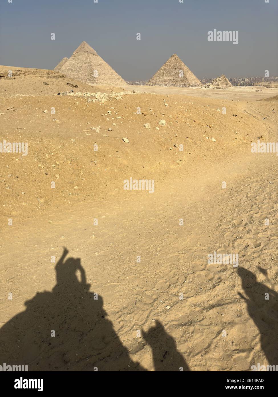 Shadow cast on the sand of camel riding near the Giza Pyramids, Egypt ...