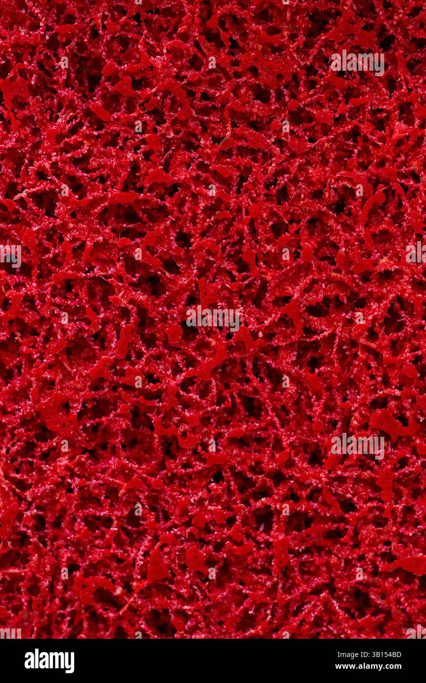 a porous structural surface close-up, red background, grinding wheel ...