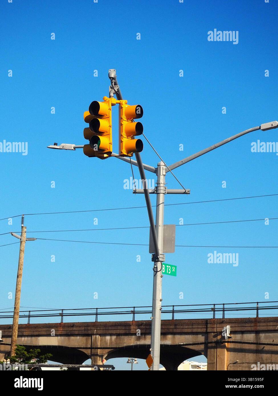 Bright yellow traffic lights against a clear blue sky in Far Rockaway ...