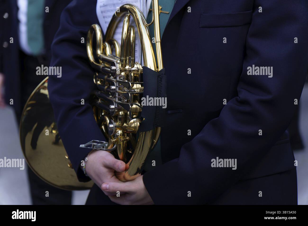 Musician in elegant uniform holding a french horn, ready to play a ...