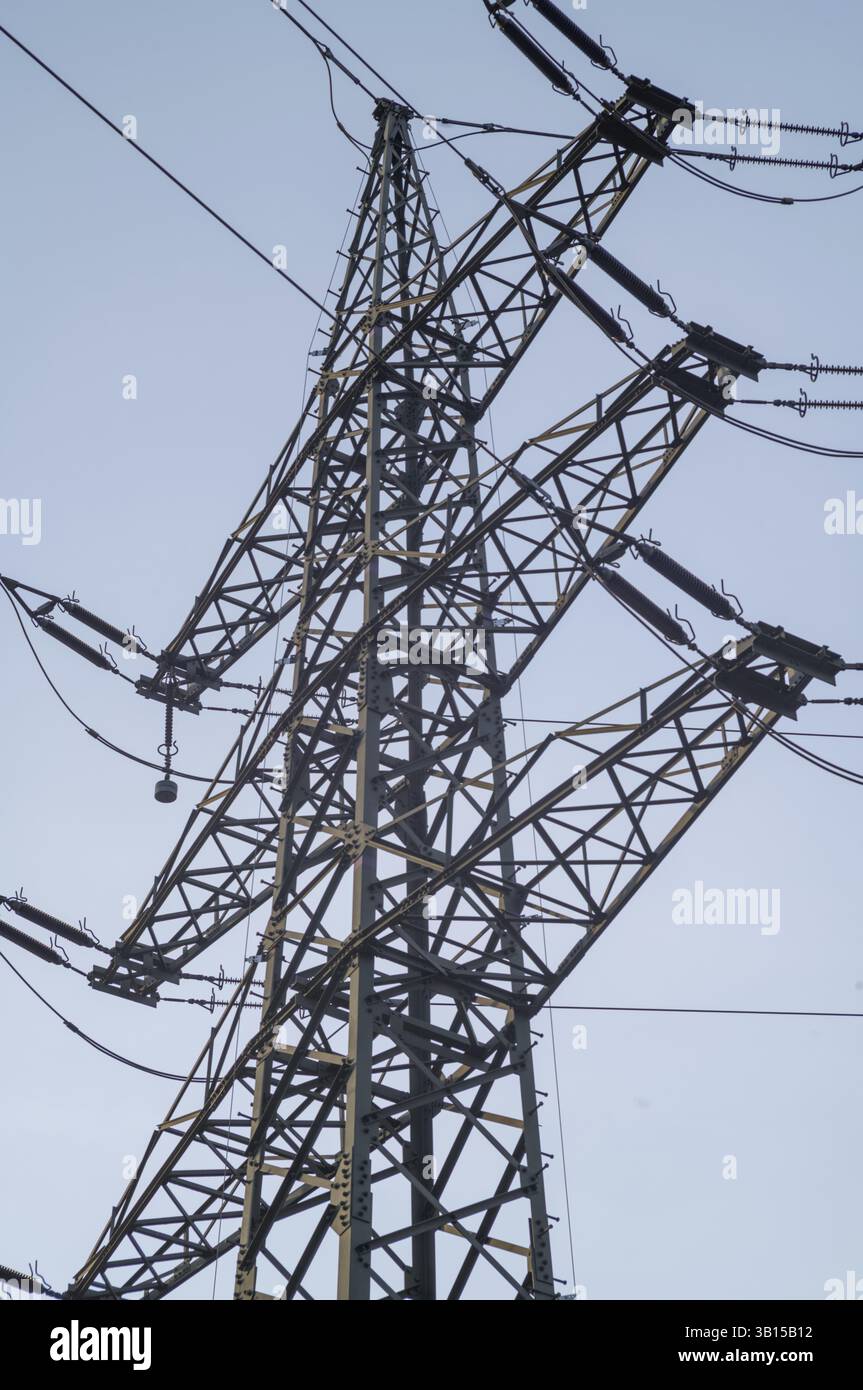 Metal electricity pylon standing tall against a clear sky, with power ...
