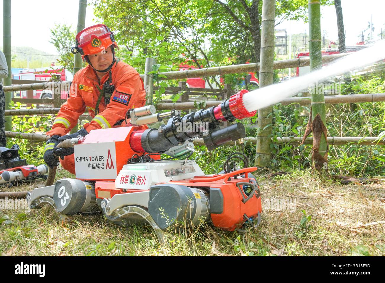 A forest firefighter operates a robot dog to carry out fire-fighting ...