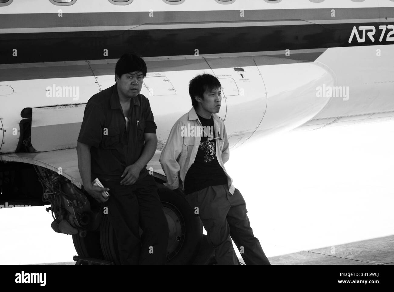 Aircraft Ground Crew Resting on ATR72 Landing Gear at Urumqi Airport ...