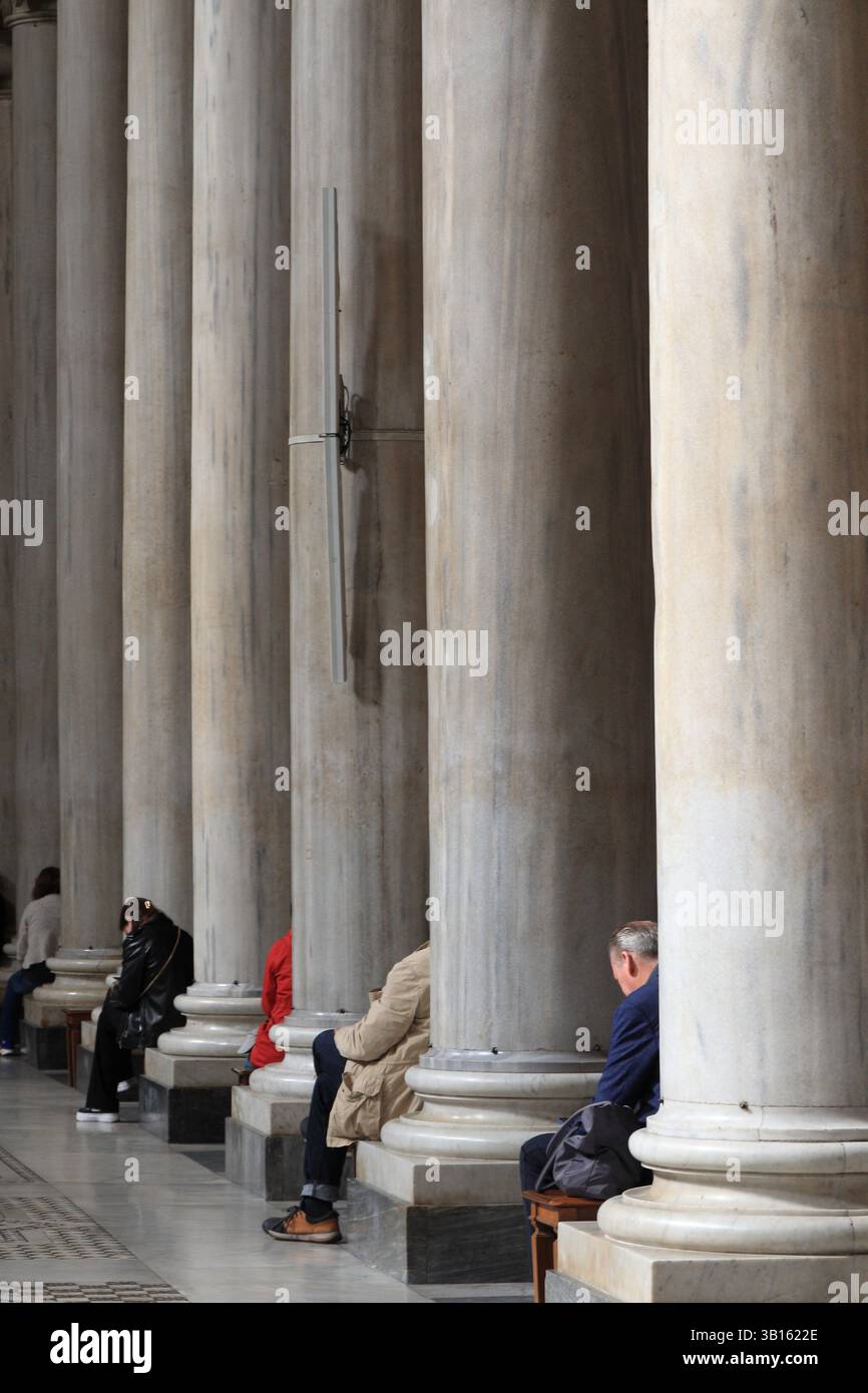 People sitting on the base of white columns at the Santa Maria Maggiore ...