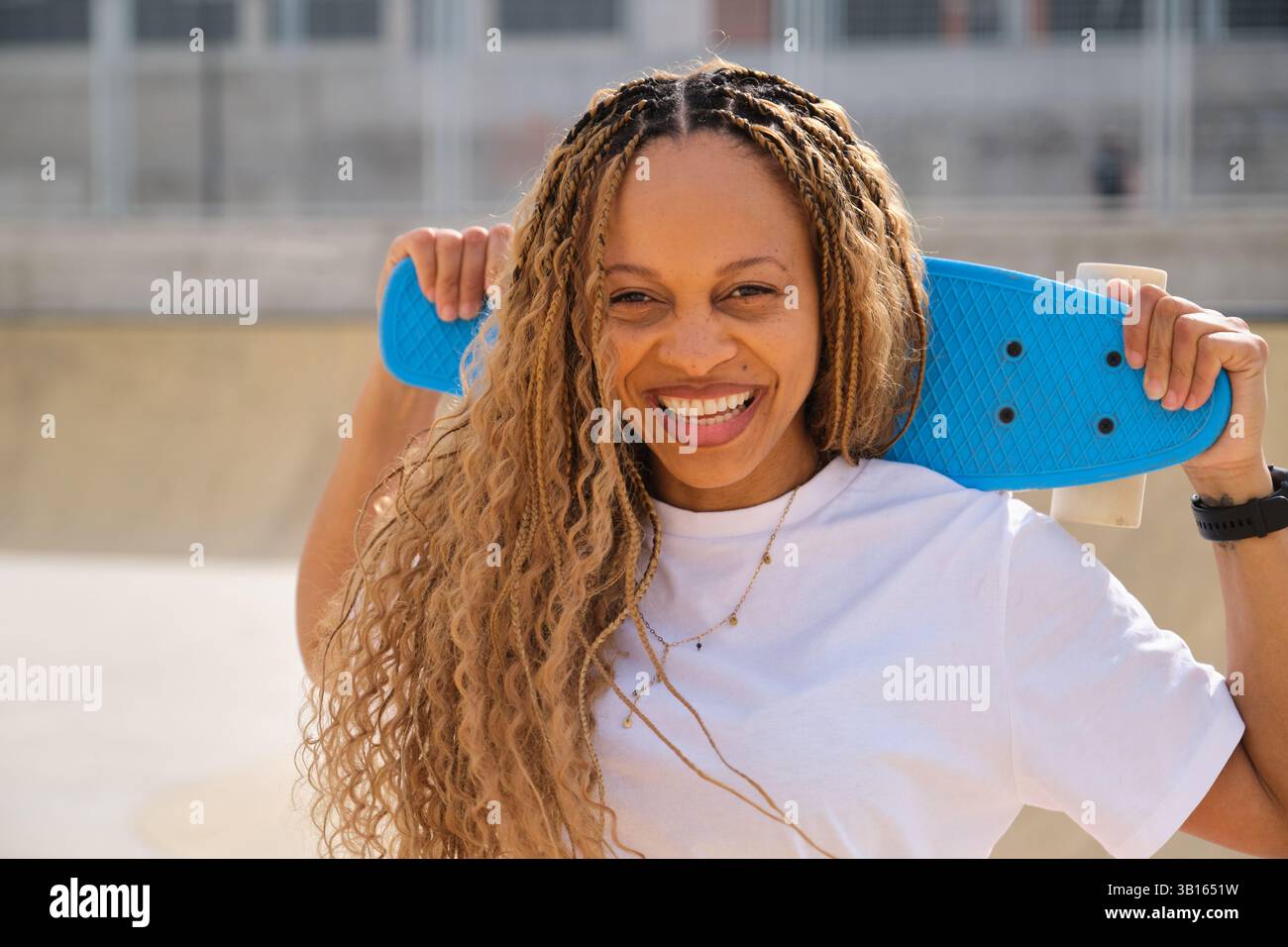 Happy skater holding blue penny board smiling at skatepark Stock Photo ...