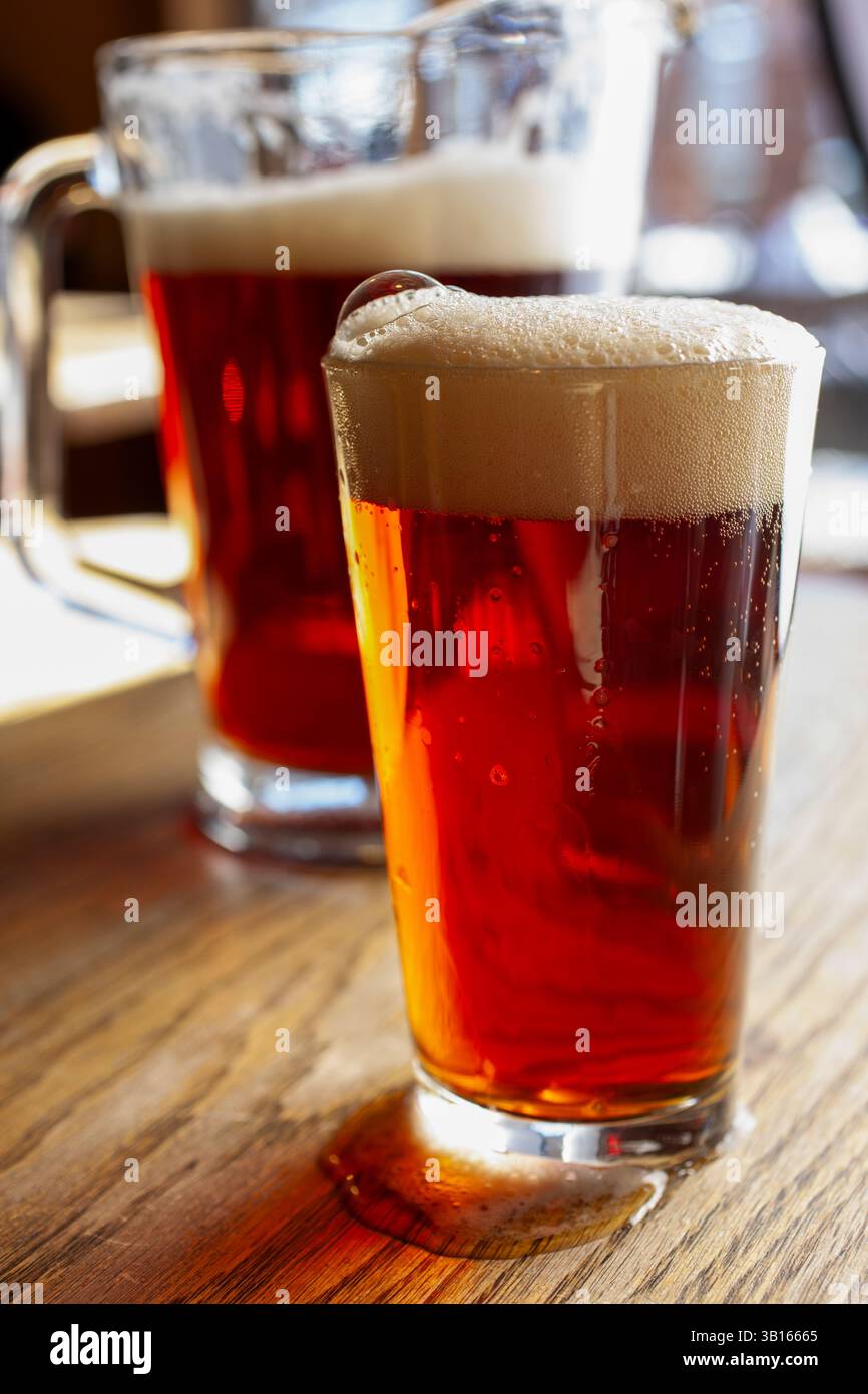 Close up view of glass of beer with foamy head and pitcher Stock Photo ...