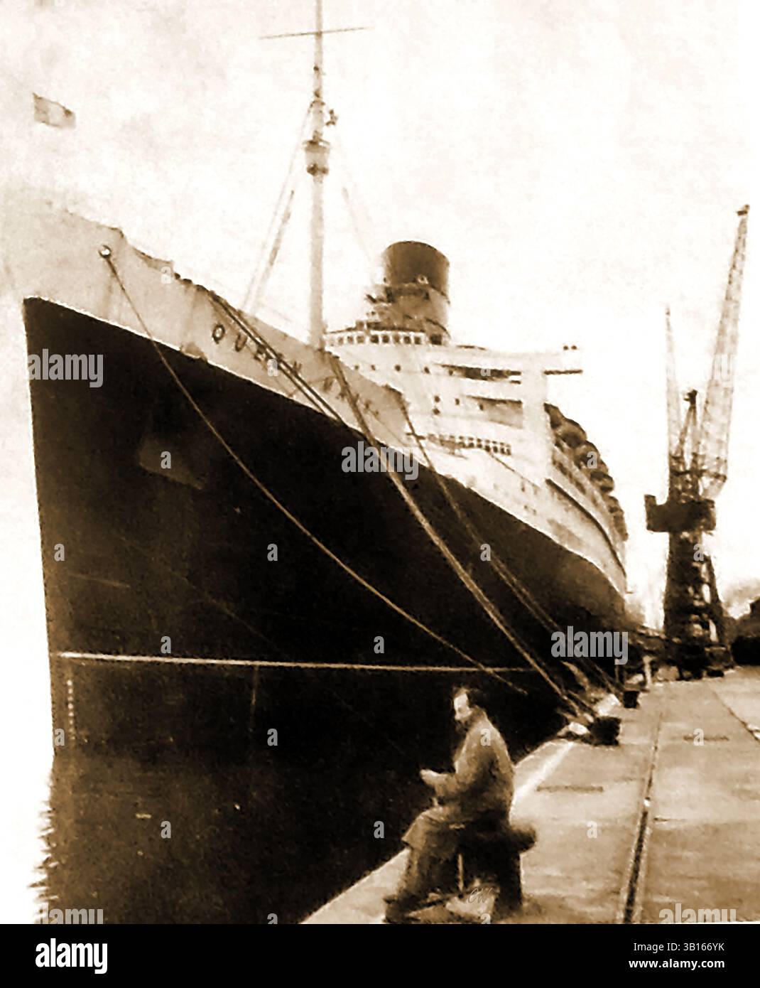 1950's - A lone fisherman near the Queen Mary at Southampton Dock ...