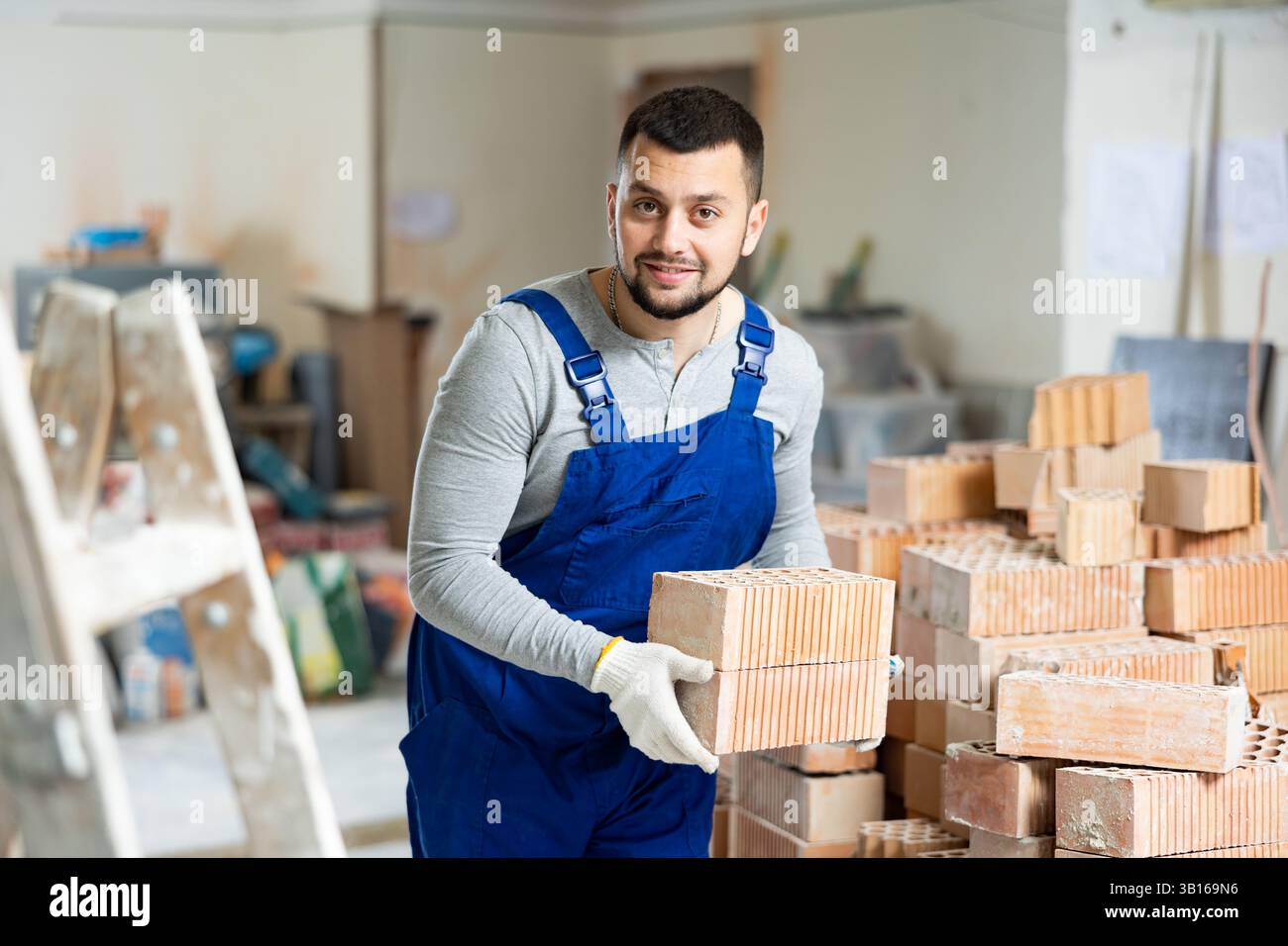 Construction worker carrying bricks at renovating object Stock Photo ...