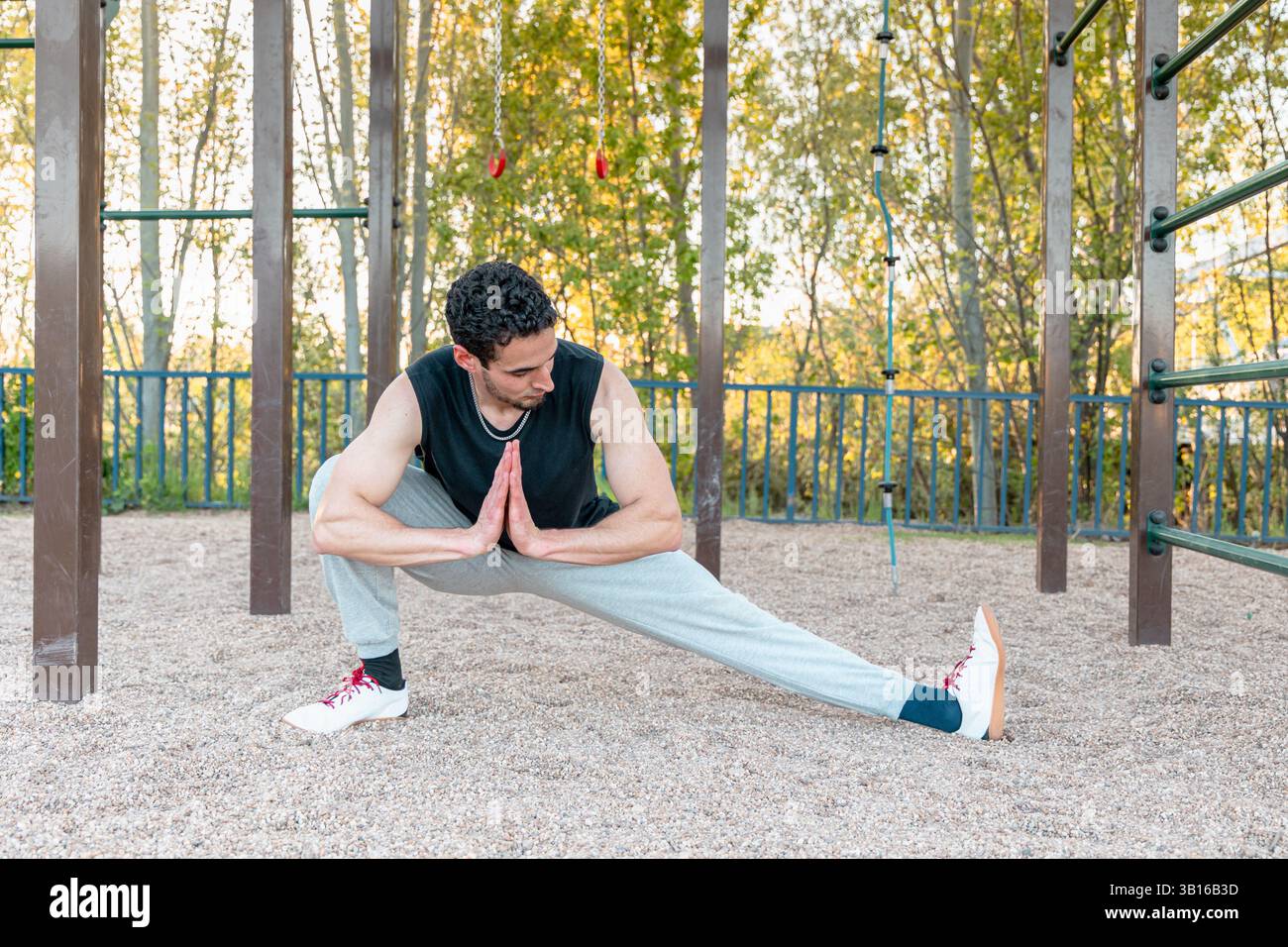 Man performing Cossack squat stretch in outdoor calisthenics park for ...