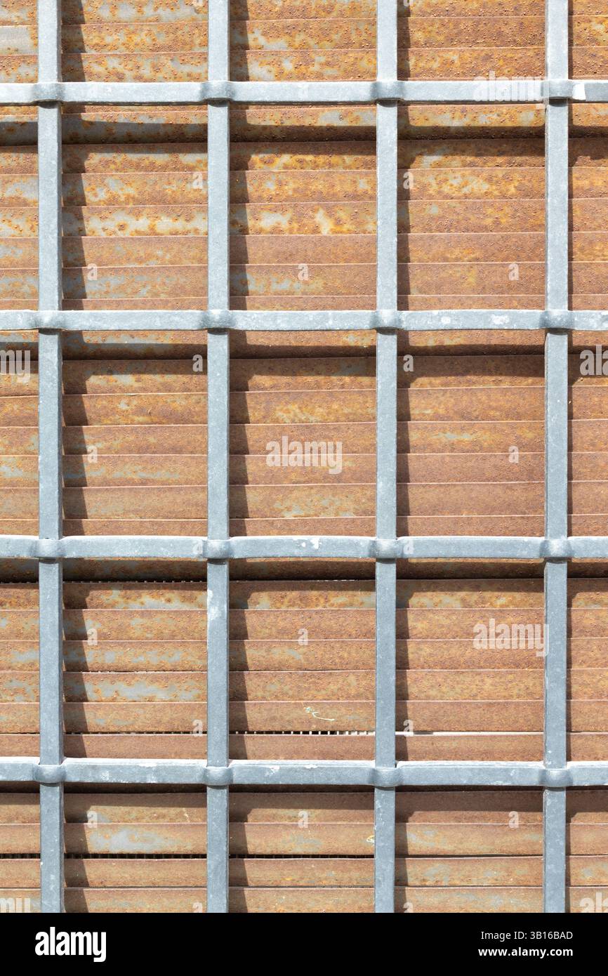 Metal grid structure over weathered rusted steel with industrial ...