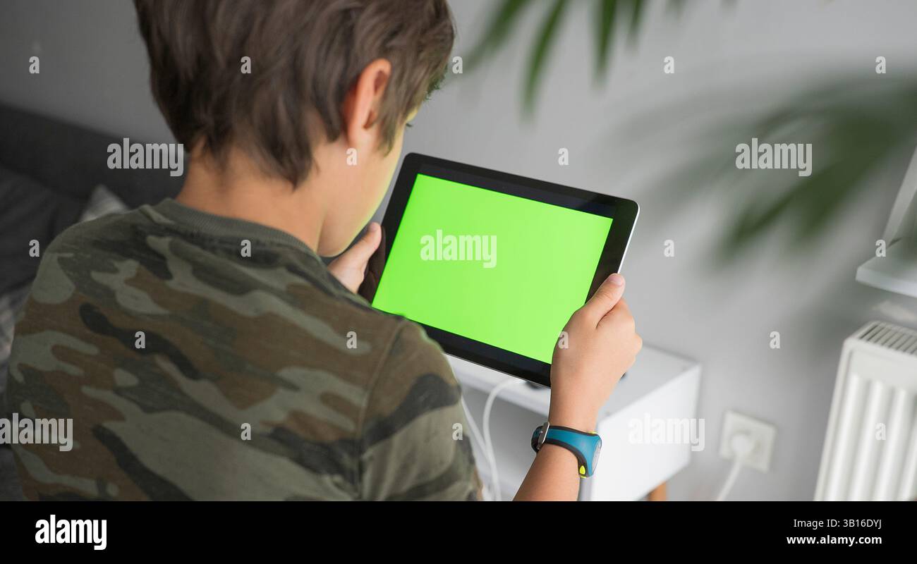 Boy using social media on tablet with chroma key background ...