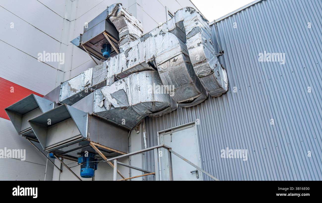 Large insulated ventilation ducts and industrial fans attached to a ...