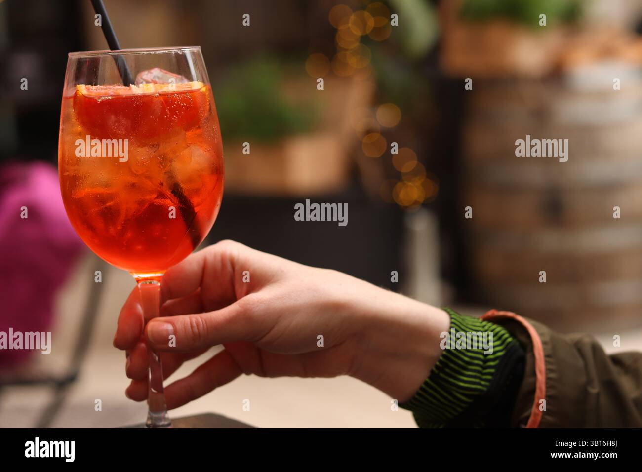 Glass with Aperol Spritz in a woman's hand. Cold refreshing alcoholic ...