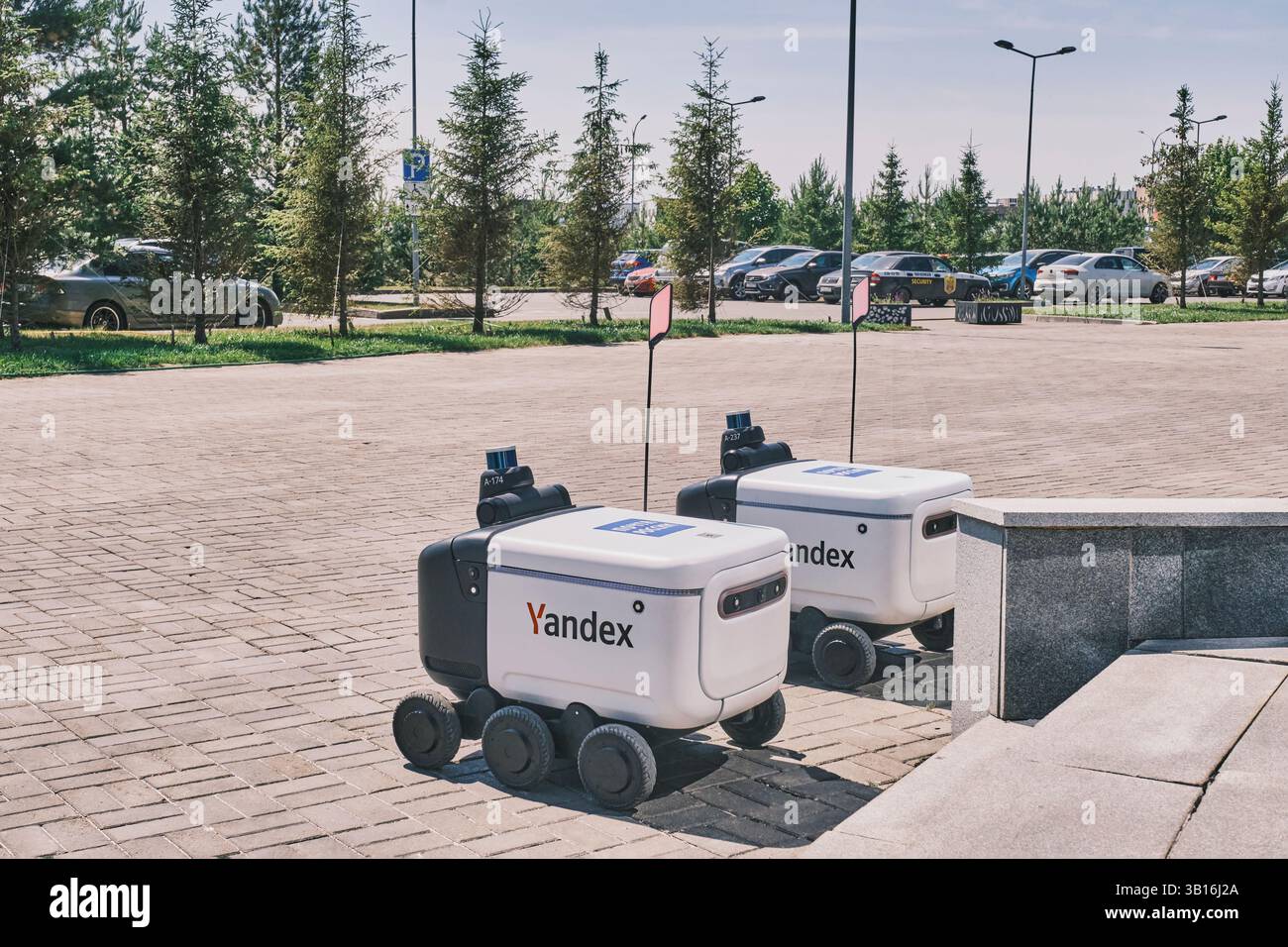 Two autonomous delivery robots equipped with sensors and lidar parked outdoors in Innopolis ...