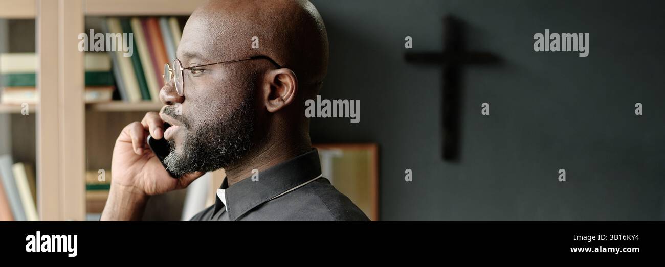 Website banner of African American pastor talking on smartphone while ...