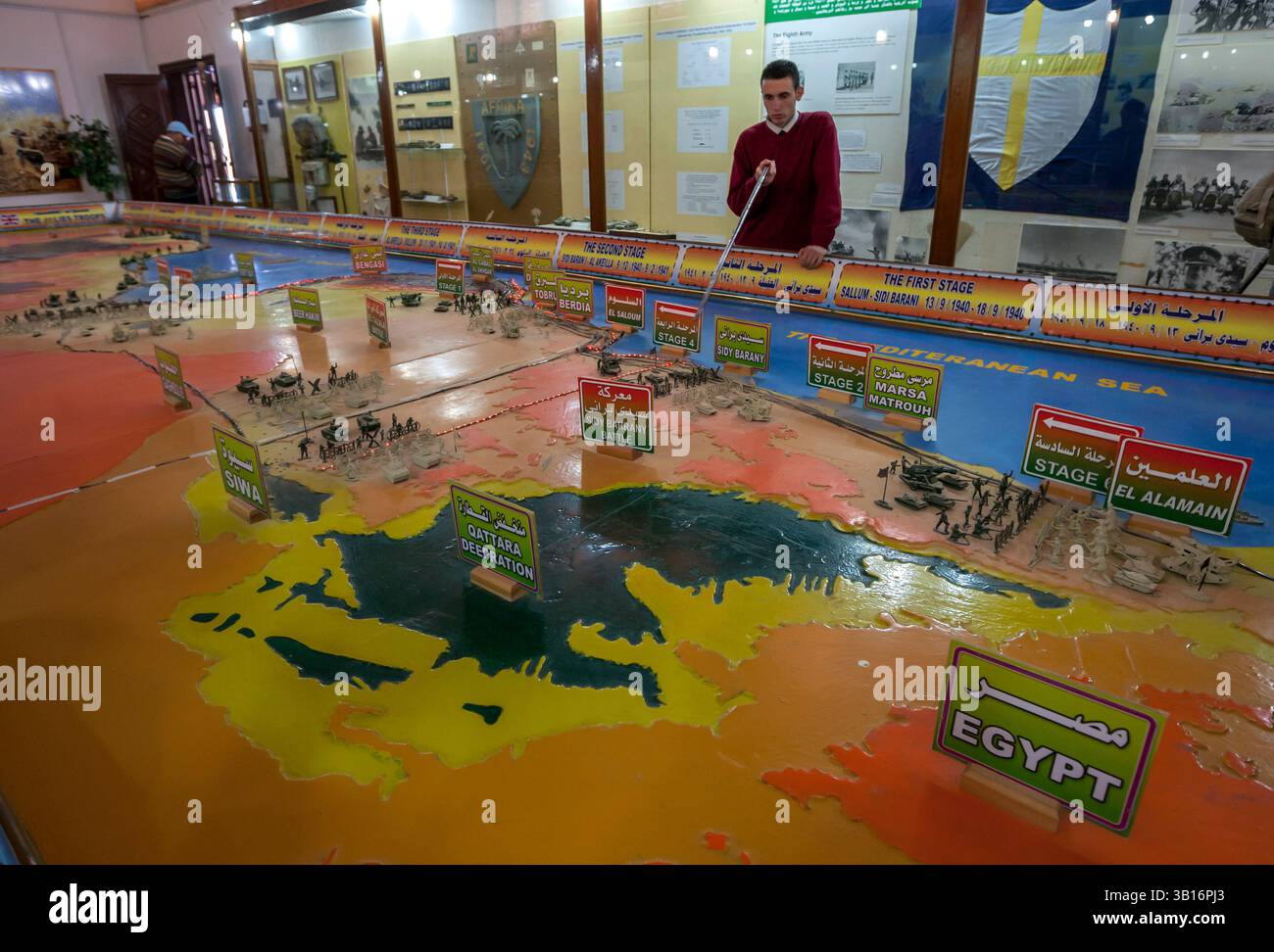 An Egyptian man points out on a table map the various stages of the ...