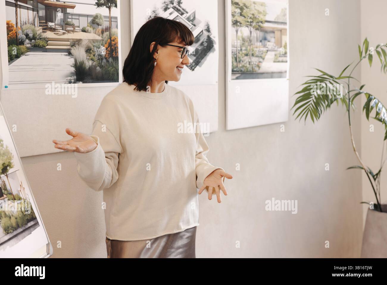 A businesswoman stands in a modern workspace, presenting architectural ...