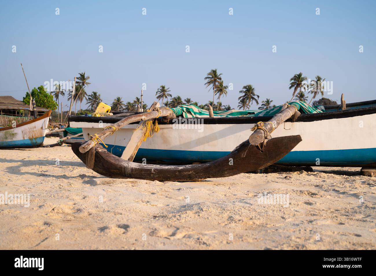 Old wooden boat on the beach in Goa, palm trees, South India, tropical ...