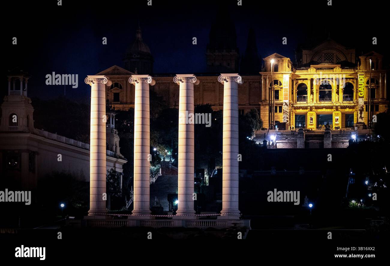 Illuminated ancient columns at night with a historic building in the ...