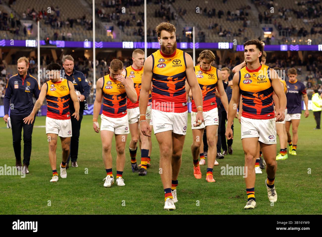 Riley Thilthorpe of the Crows and his teammates leave the field after ...