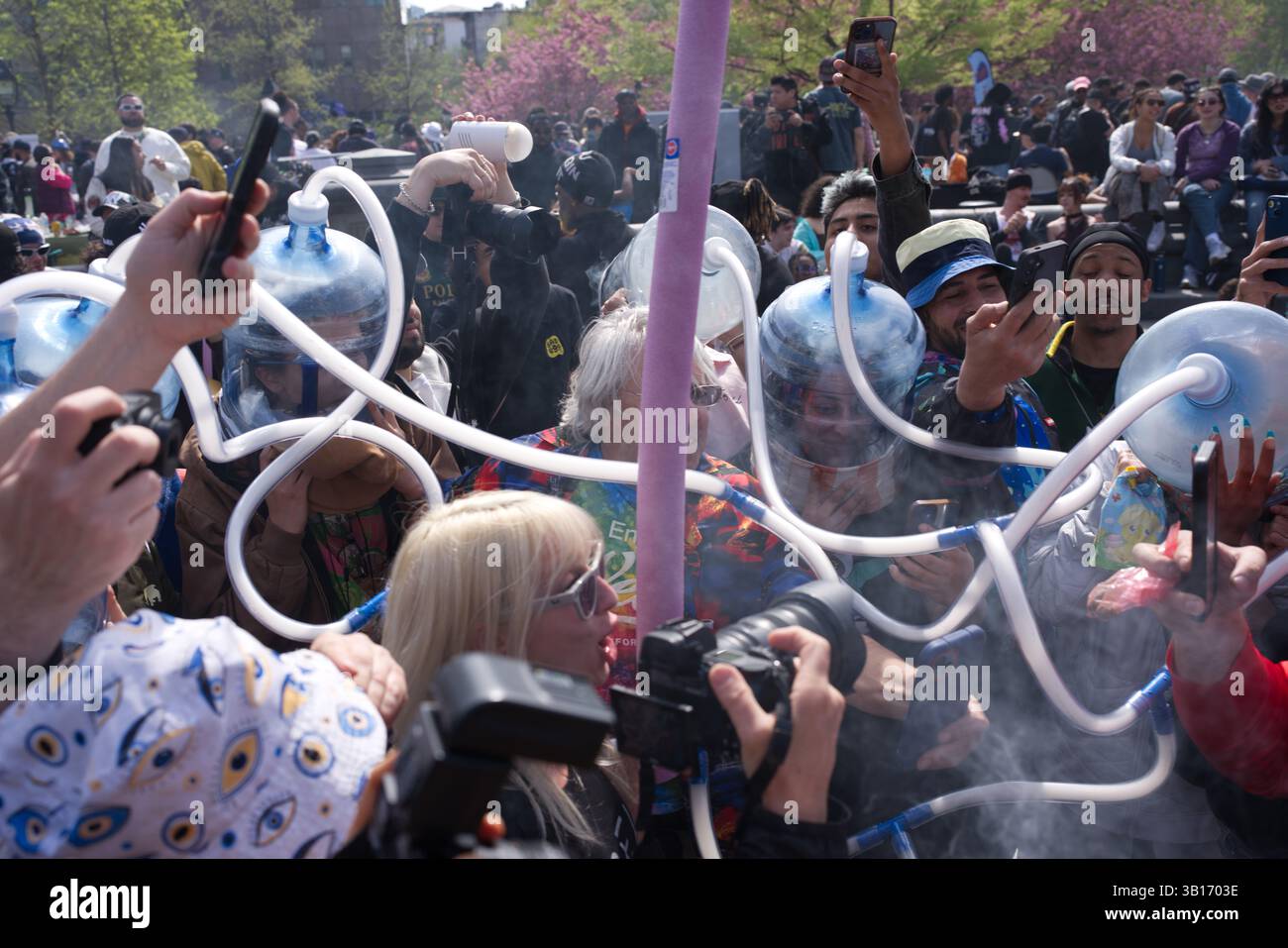 A crowd of people, many wearing water cooler helmets connected by ...
