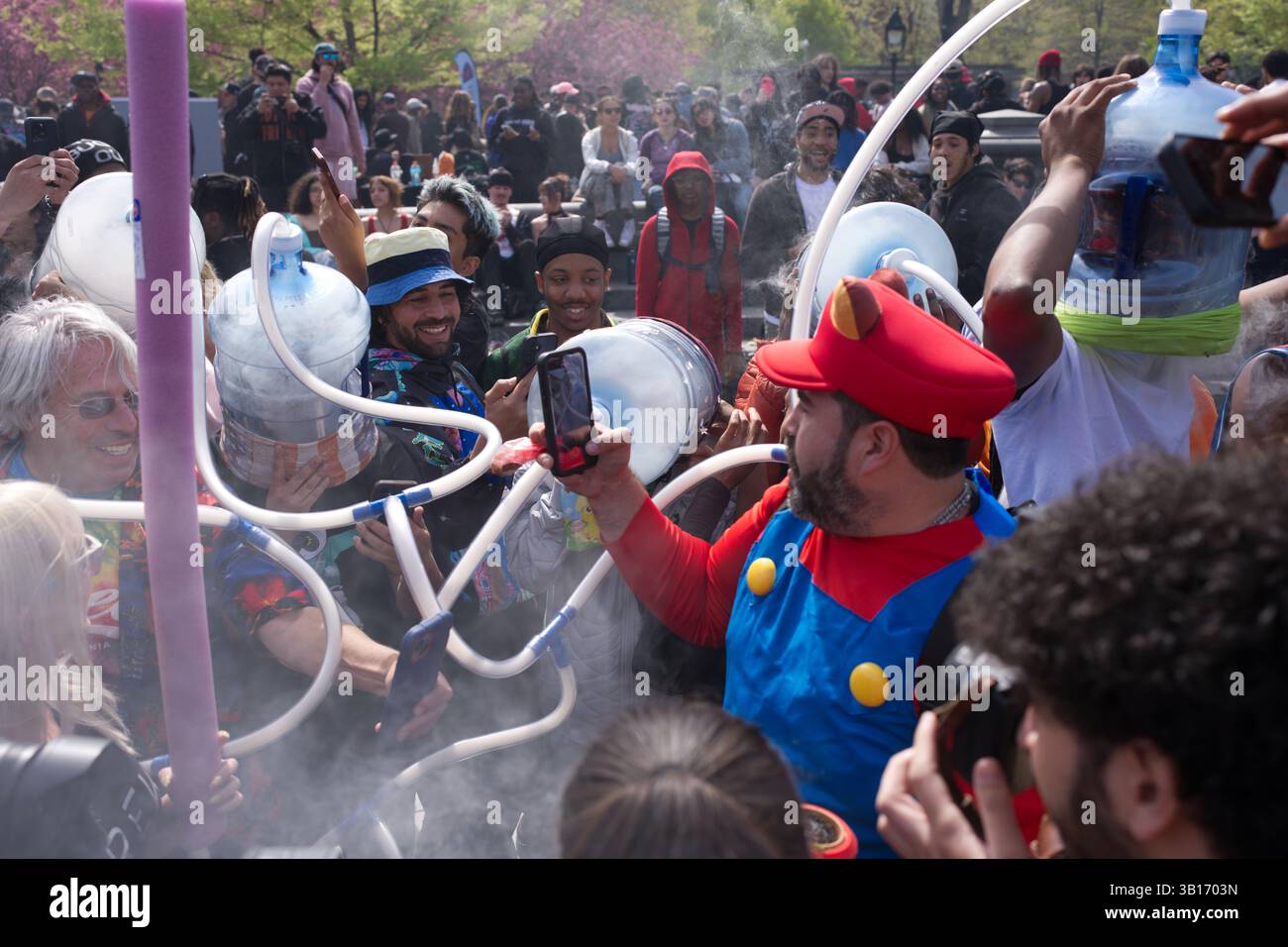 A crowd of people participate in an outdoor event, using large plastic ...