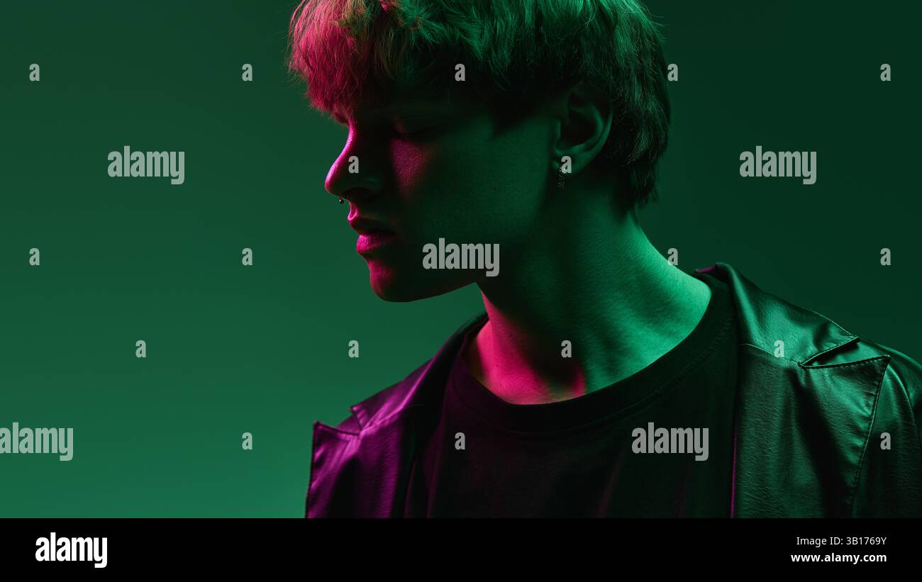 Side profile of young man with peaceful expression under vibrant ...