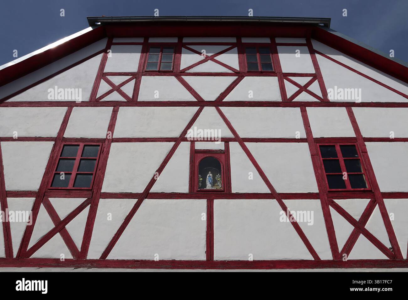 Holy Mary figure in glass shrine on the facade of a half-timbered house ...