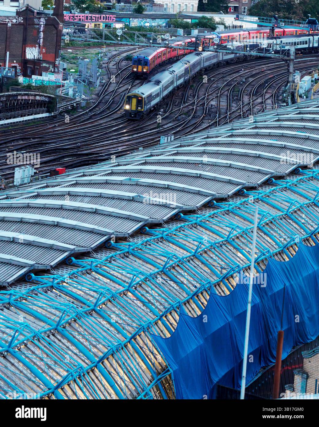 Commuter trains navigate the complex track network near a station ...