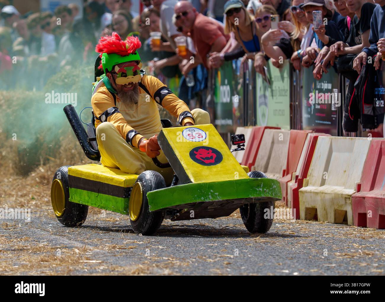 A racer dressed as Bowser from Mario Kart speeds down the track in a ...