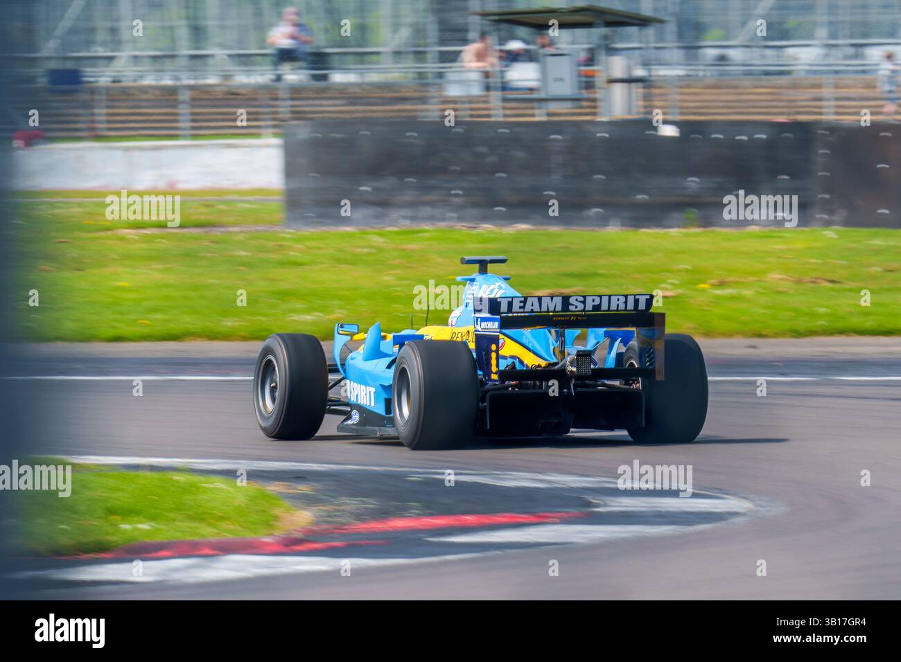 A blue and yellow Renault Formula One car speeds around Silverstone ...