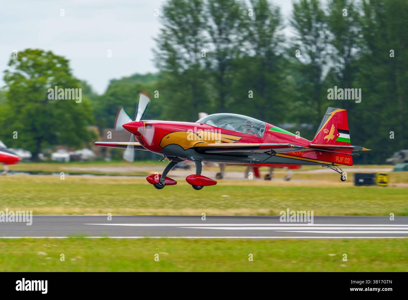 A red and gold Extra 330 aerobatic aircraft in action at the Royal ...