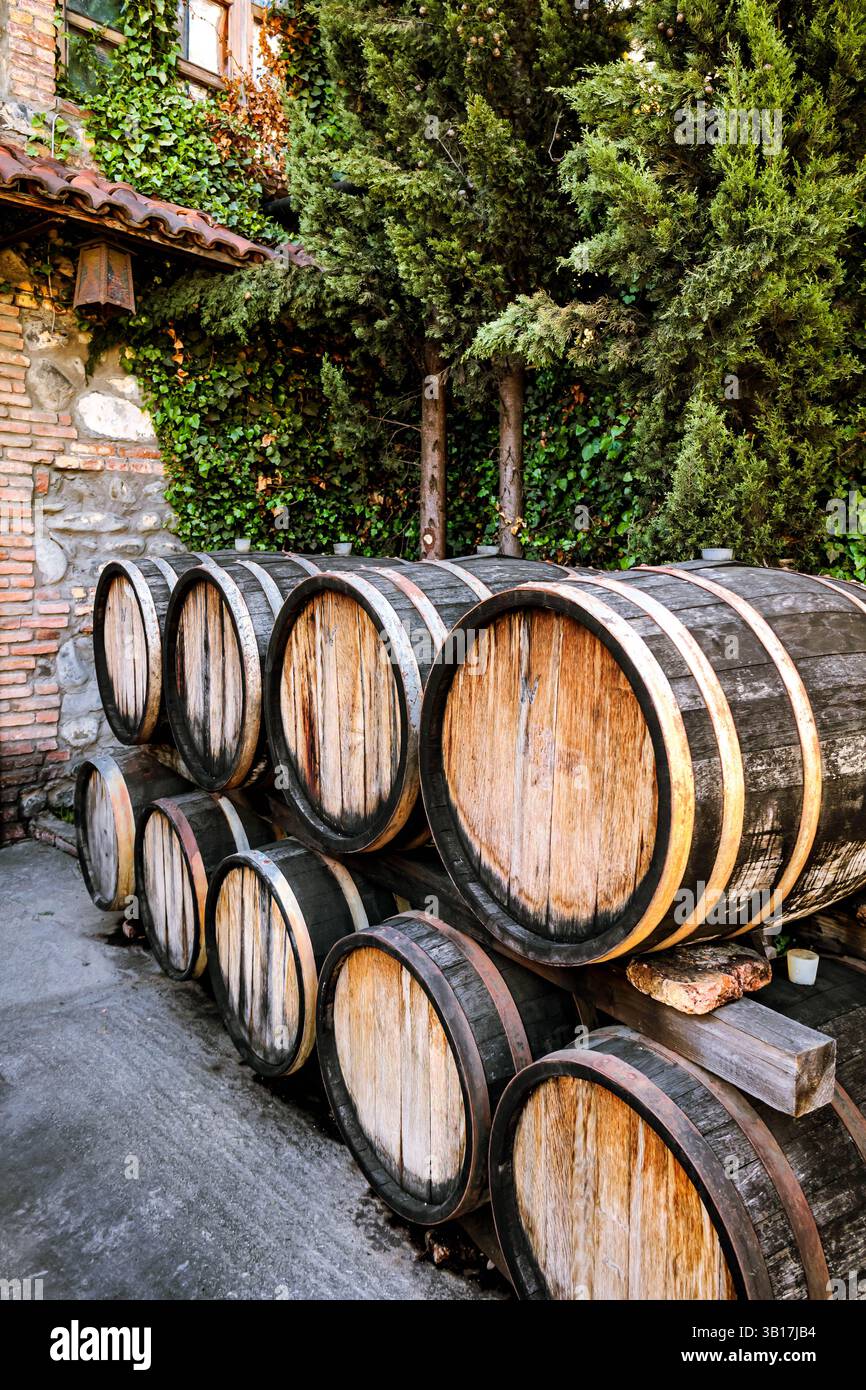Wooden wine barrels stacked in a traditional Georgian winery courtyard ...