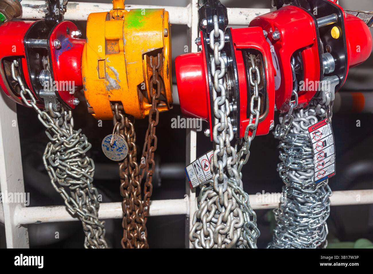 Chain hoists for lifting weights in a workshop close-up Stock Photo - Alamy