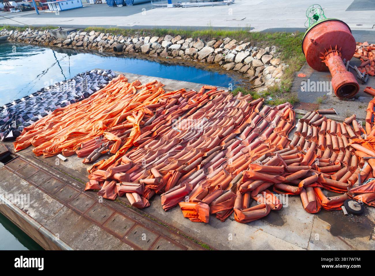 A sea buoy and booms lie on the pier of the seaport Stock Photo - Alamy