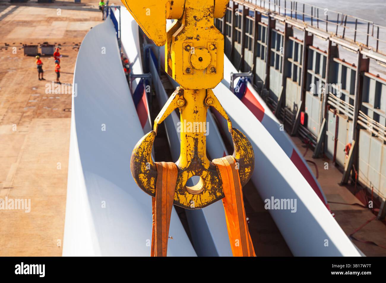 Loading wind generator blades using a crane onto a cargo ship at a ...