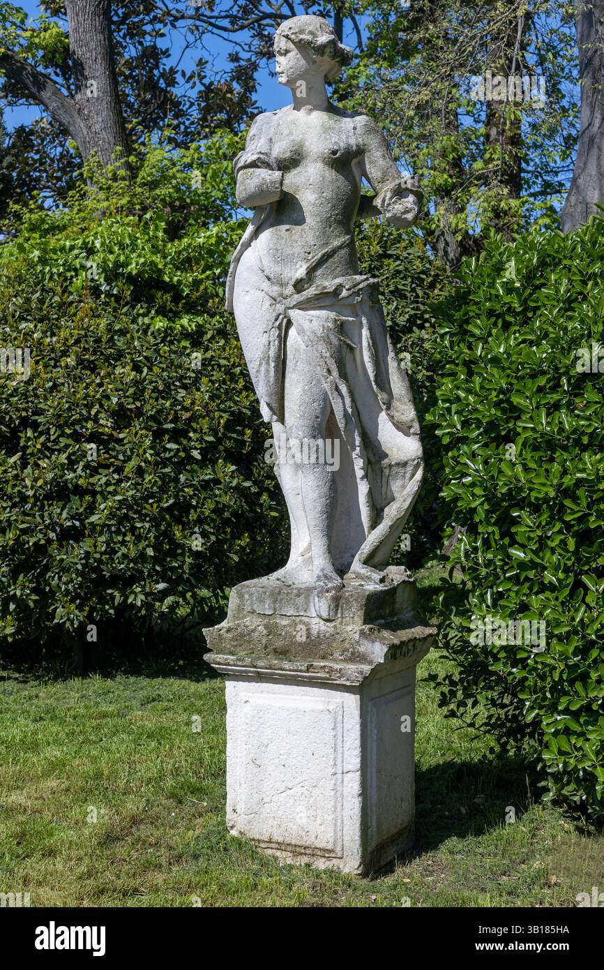 Weathered stone statue in green garden Stock Photo - Alamy