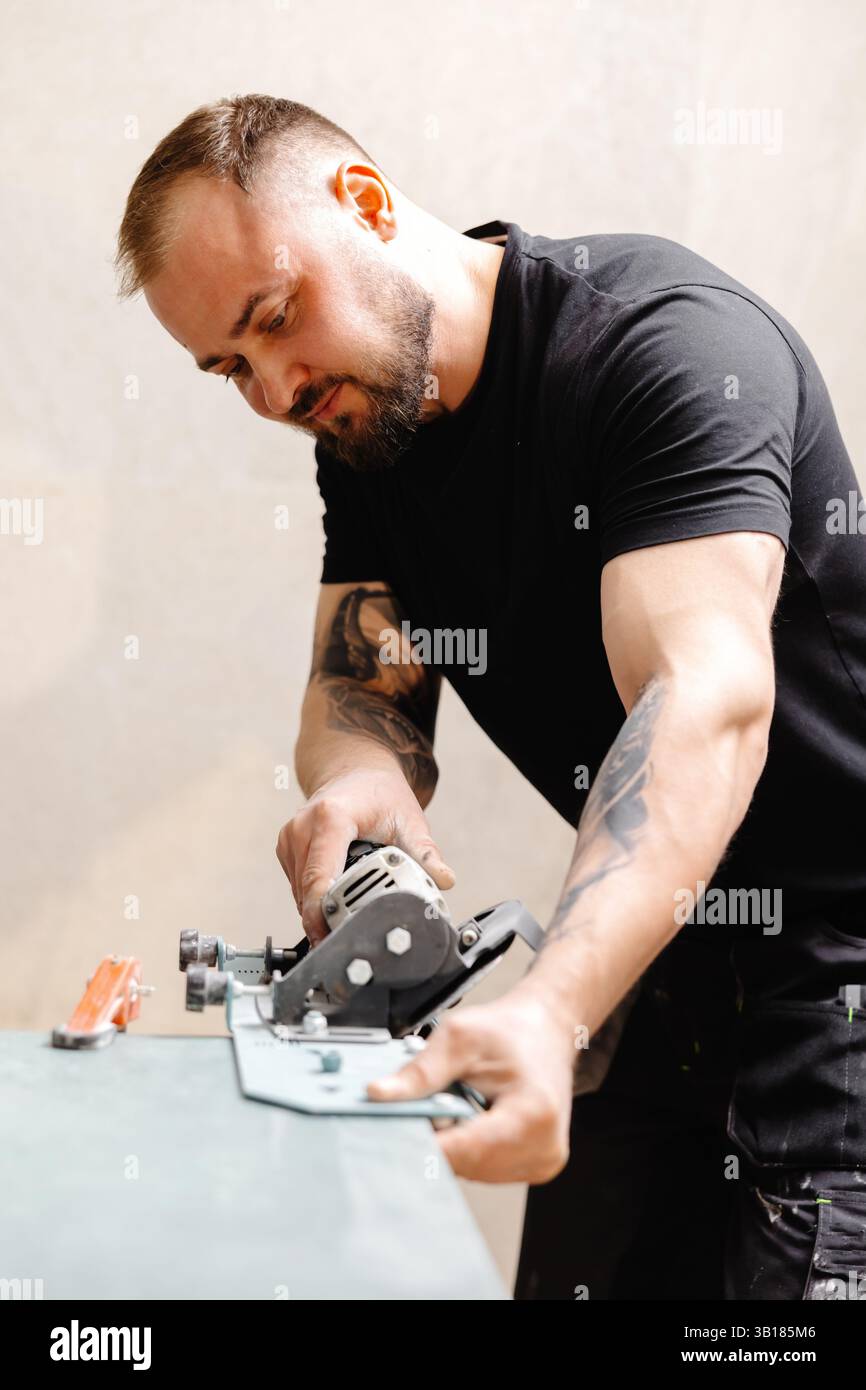 Construction worker cutting ceramic tiles using a tile saw during ...