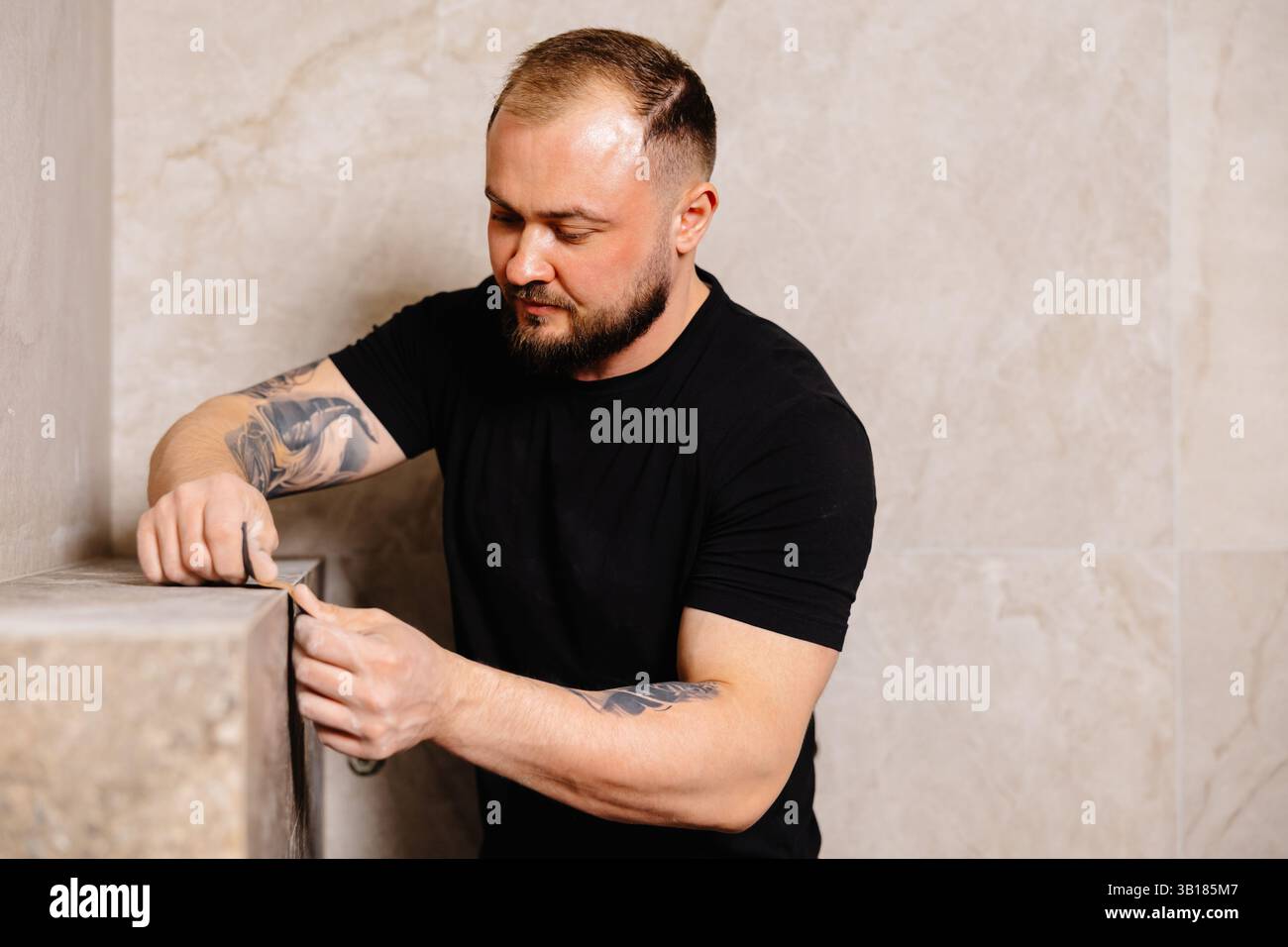Builder placing ceramic tiles on a wall, skillfully transforming a ...