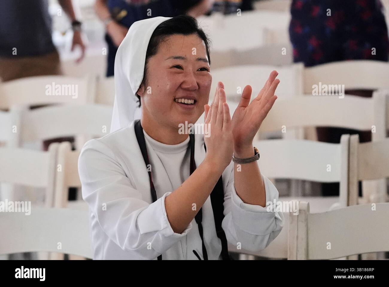 Sister Boram Lee of the Salesian Sisters applauds in the audience as ...